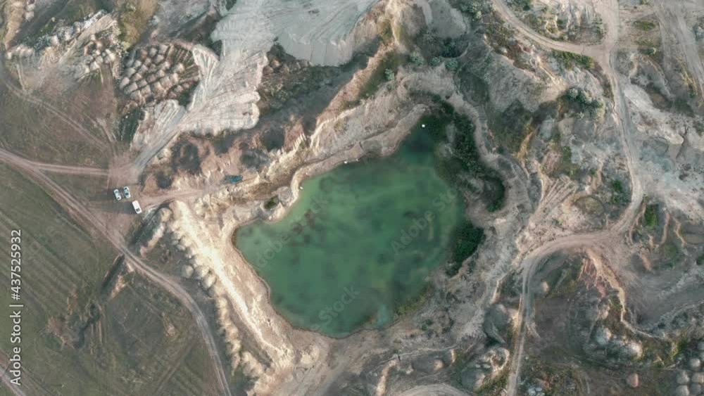 Aerial view of car by the edge of a flooded quarry. Drone footage of a ...
