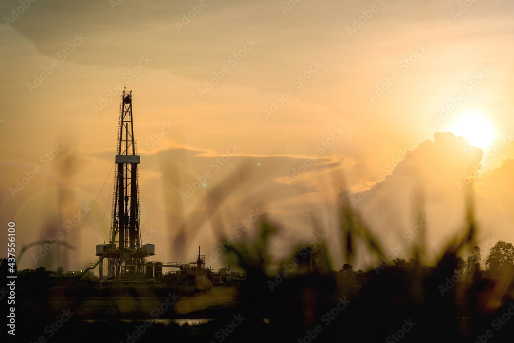Crude oil drilling rig in silhouette with dramatic sky as background ...