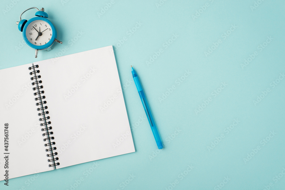 Top view photo of open workbook blue pen and alarm clock on isolated ...