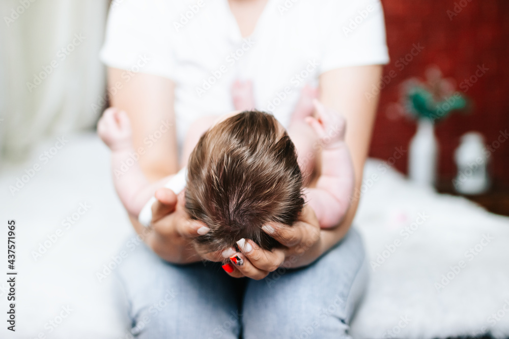A mother holds the head of a newborn baby in rivers on her lap. Mother ...