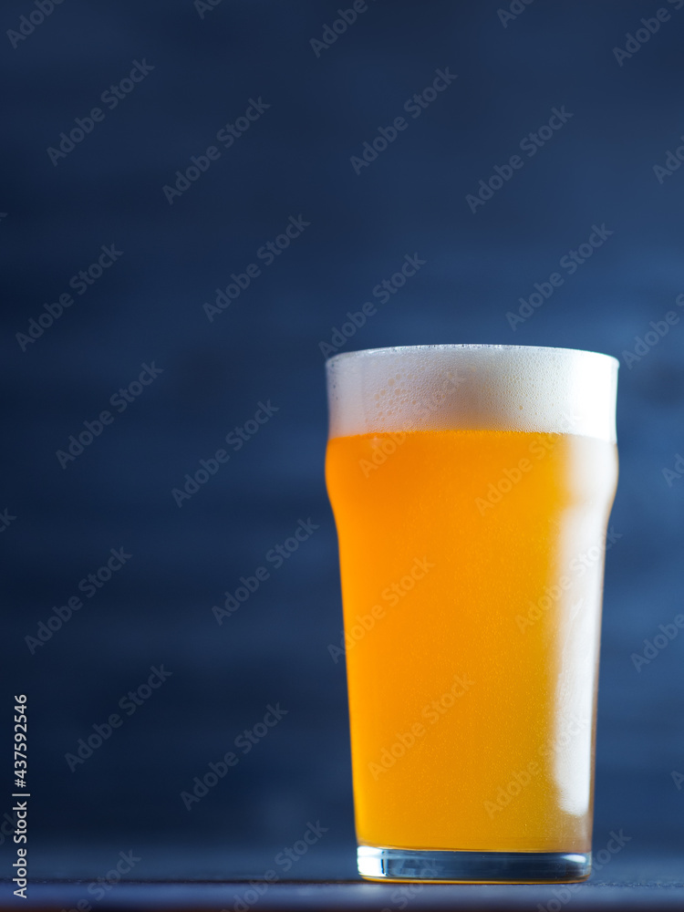 New England IPA beer glass on dark blue wooden background Stock Photo ...
