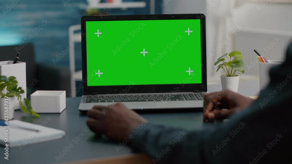 Close up of african american man using green screen laptop in bright ...