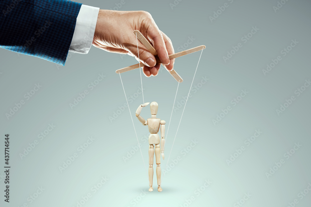 Male hand, puppeteer controls puppet, doll salutes, soldier. The ...