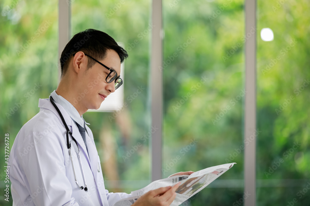 asian doctor reading a newspaper in medical office Stock-Foto | Adobe Stock