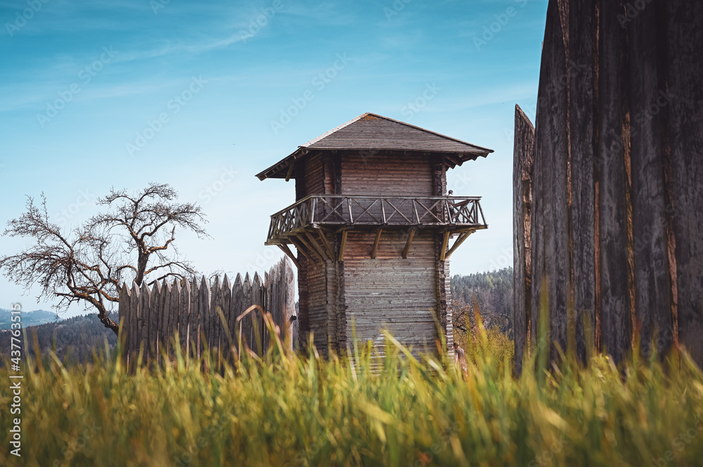 A reconstructed wooden Roman watchtower and a wooden border fence under ...