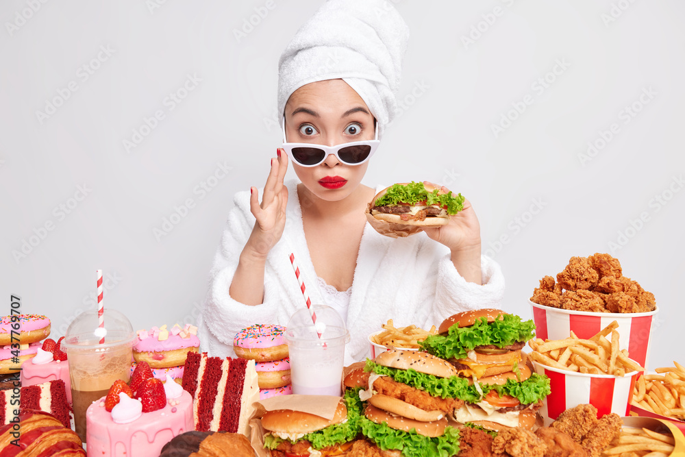 Unhealthy eating and junk food concept. Surprised Asian woman wears ...
