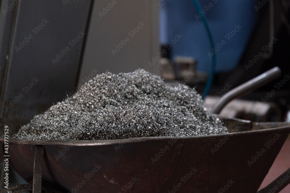 Full wheelbarrow of metal shavings. Waste from the production of metal ...