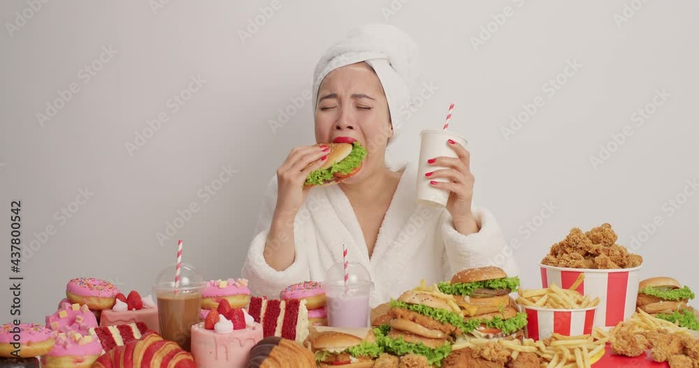 Stress eating concept. Crying depressed woman eats tasty hamburger ...