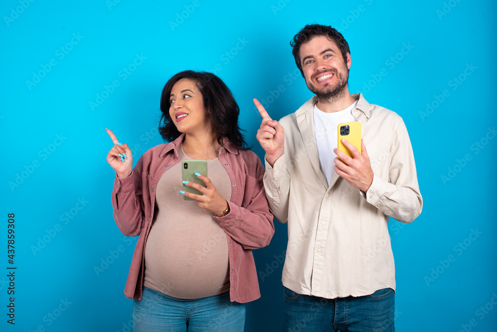 Wow!! excited young couple expecting a baby standing against blue ...