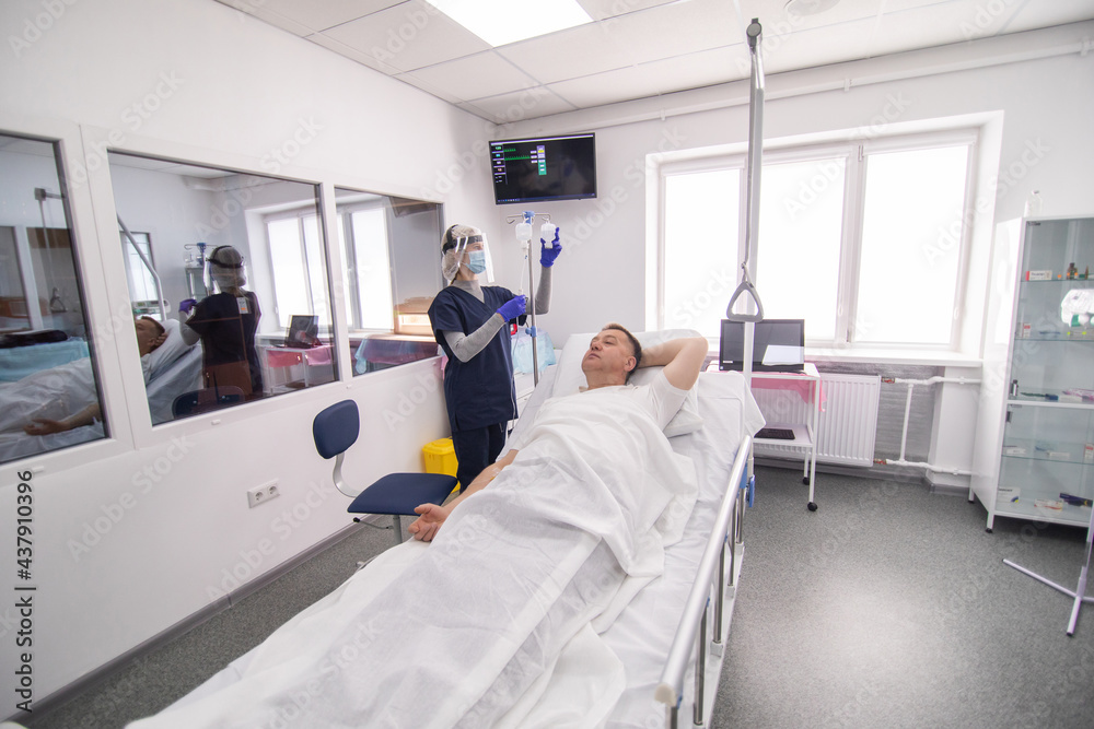 Adult patient lying on bed during intravenous injection by dropping ...