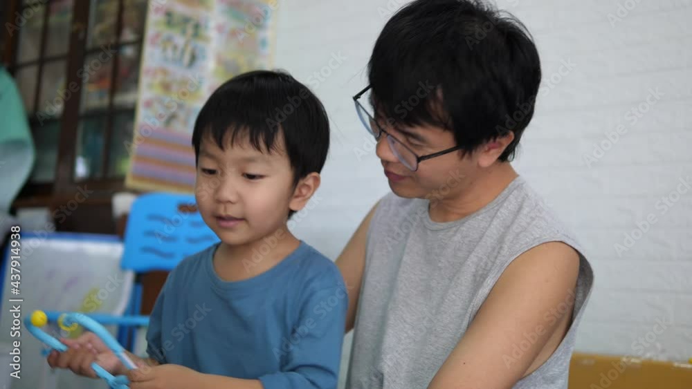 4K Authentic asian child boy playing doctor with father at home with ...