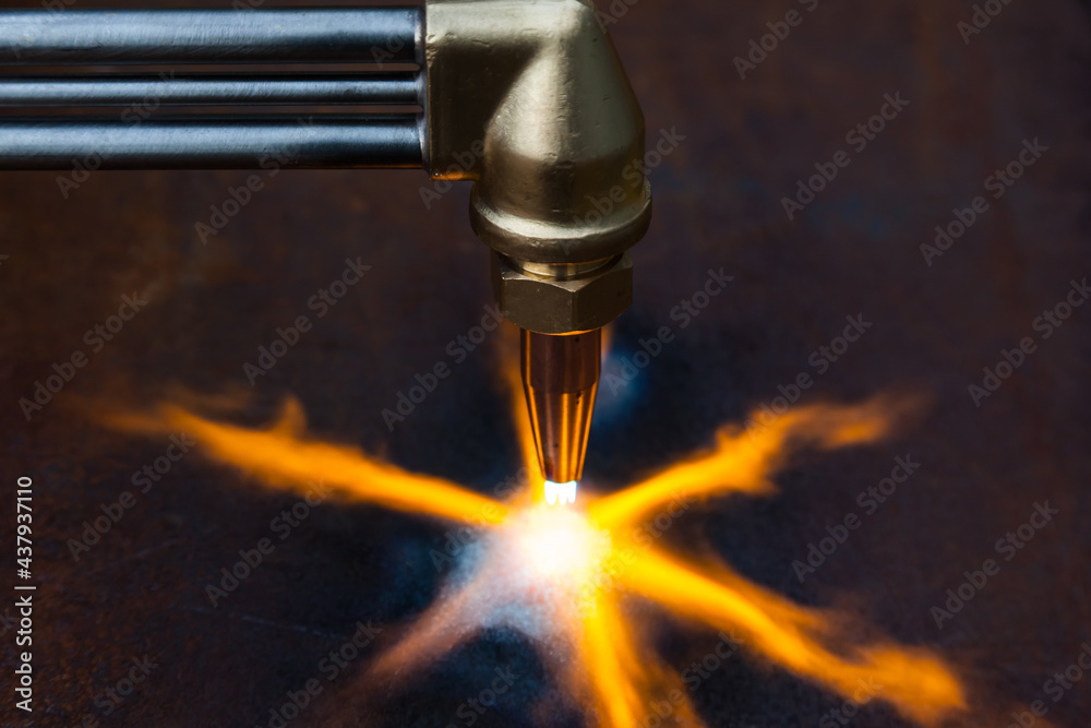 Gas cutting of metal. Gas cutter with copper nozzle with a stream of ...