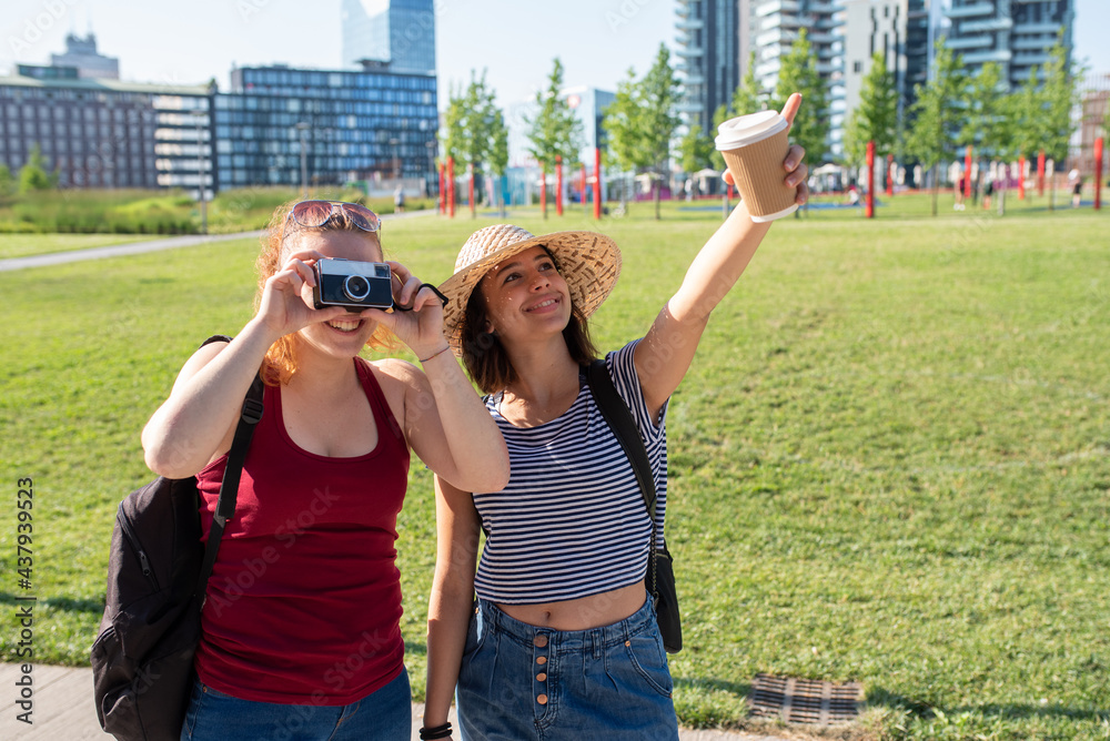 happy women tourists exploring the city, taking pictures with a vintage ...