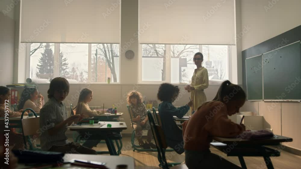 Students learning in classroom. Smart pupils writing in notebooks ...