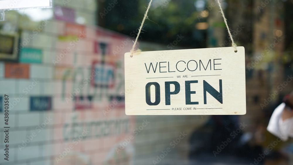 Open and closed flip sign in front of coffee shop and restaurant glass ...