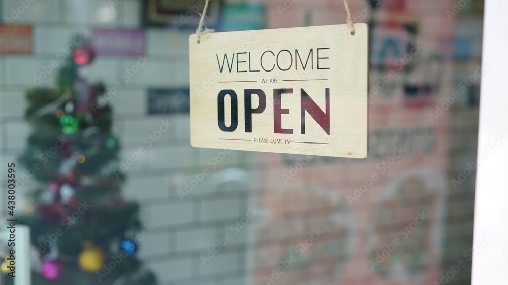 Open and closed flip sign in front of coffee shop and restaurant glass ...