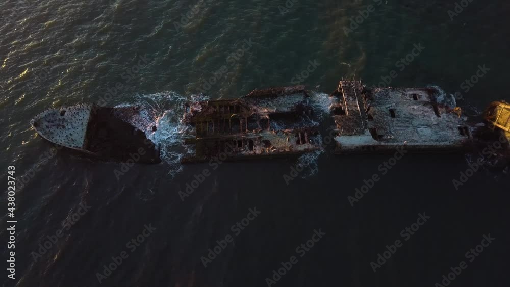 Birds flying around half sunken ship in the ocean. Old shipwreck drone ...