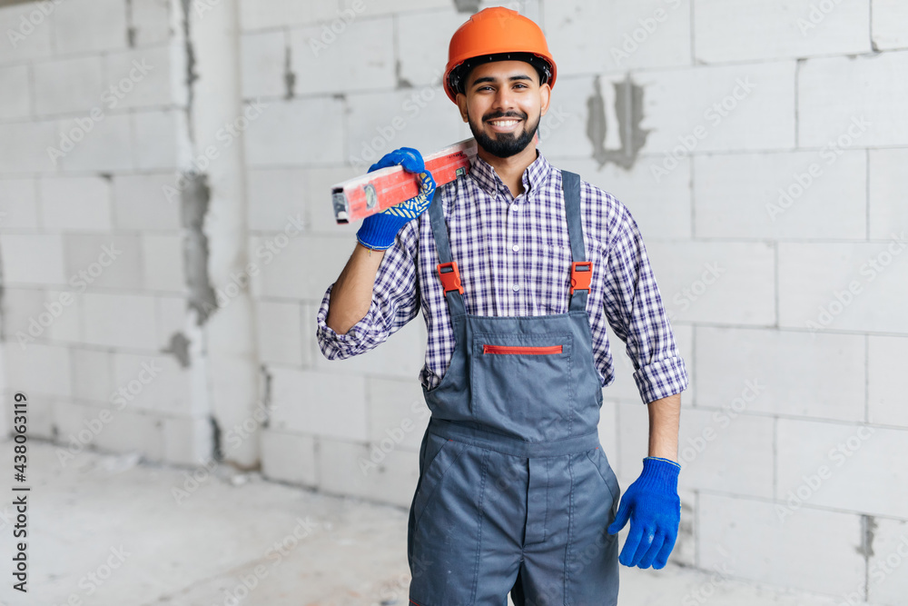 Mason checking horizontal level of house wall layer being made from ...