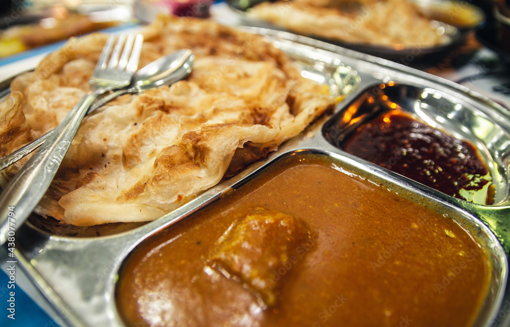 Roti canai served in an Indian restaurant. Also known as roti chenai ...