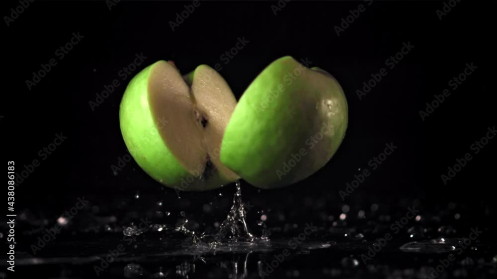 Super slow motion apple falls on the table and splits into two halves ...