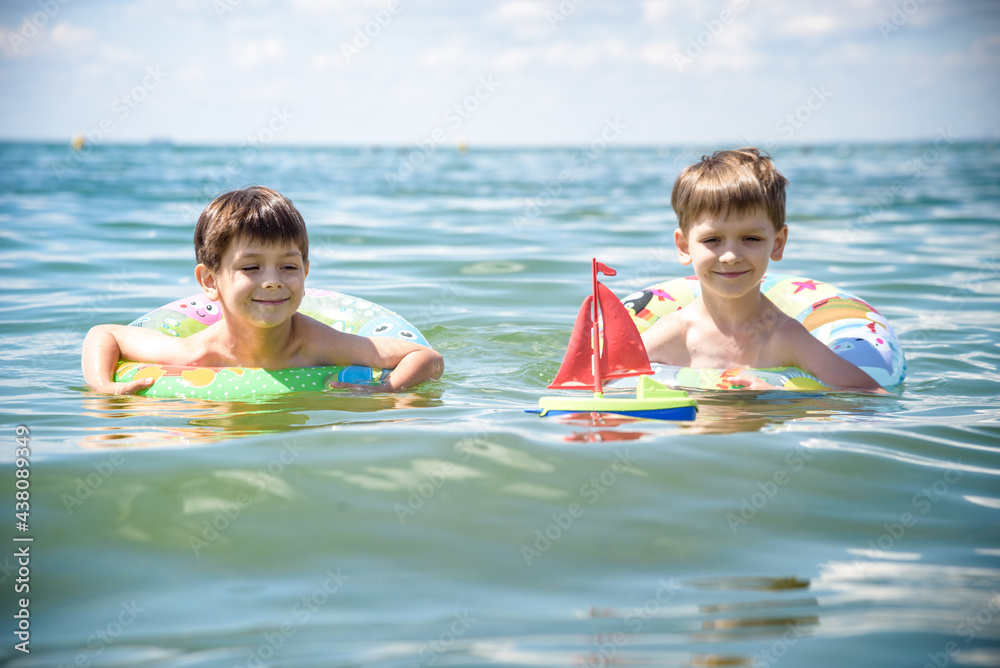 Child in swimming pool floating on toy ring. Kids swim. Colorful ...