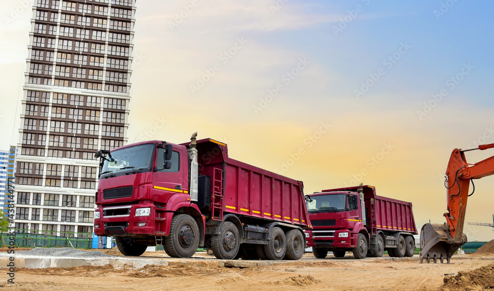 Dump truck and excavator working on earthworks at construction site on ...