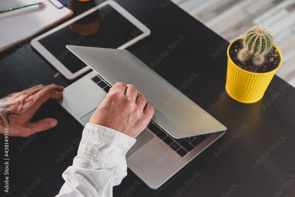 Faceless businessman opening laptop at table in office Stock Photo ...