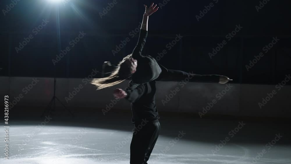 Slow motion: young couple of artistic figure skaters is performing a ...