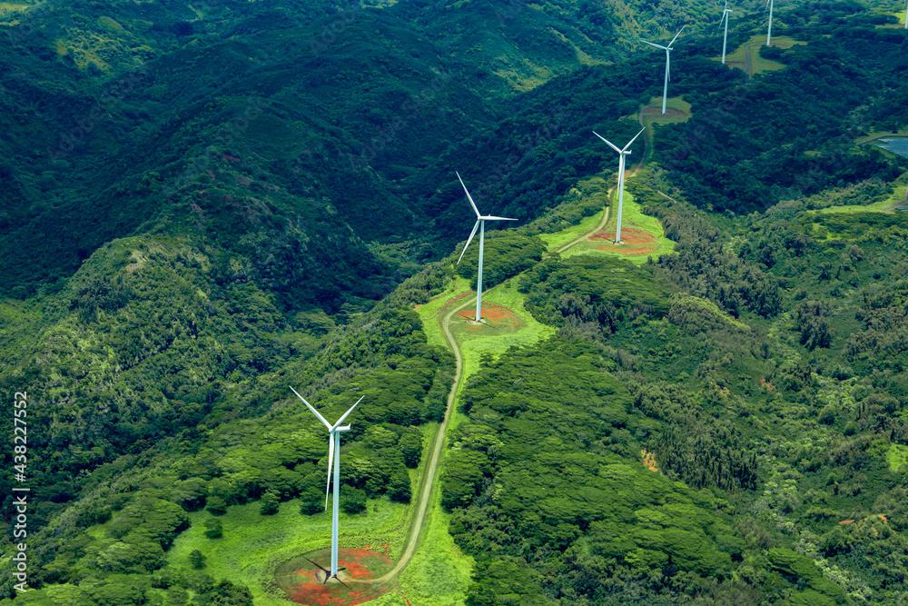 Aerial photo of white windmills in a line on green land leading off ...