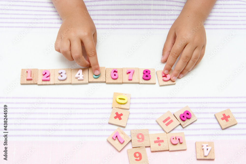 Child plays with wooden numbers, makes a chain of cisels, simple ...