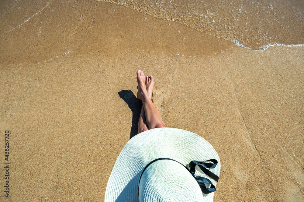 Long slim young woman legs relaxing lying down and sunbathing on sand ...