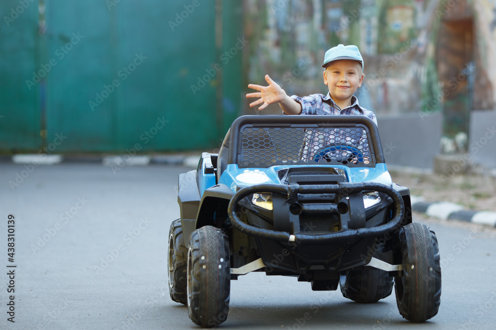 The boy plays, drives a car in the park. A cute little boy of Caucasian ...