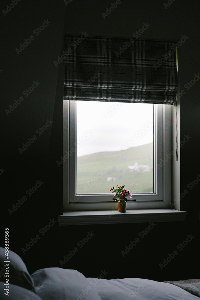 Bouquet of fresh flowers in bottle on window sill in bedroom with ...