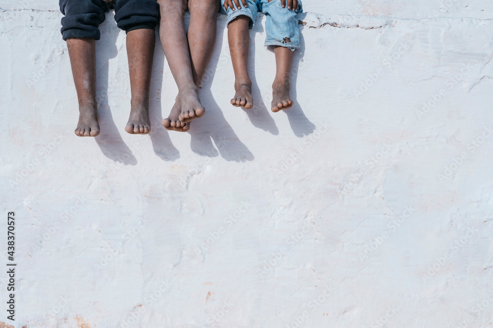 Legs of black children on white wall Stock Photo | Adobe Stock