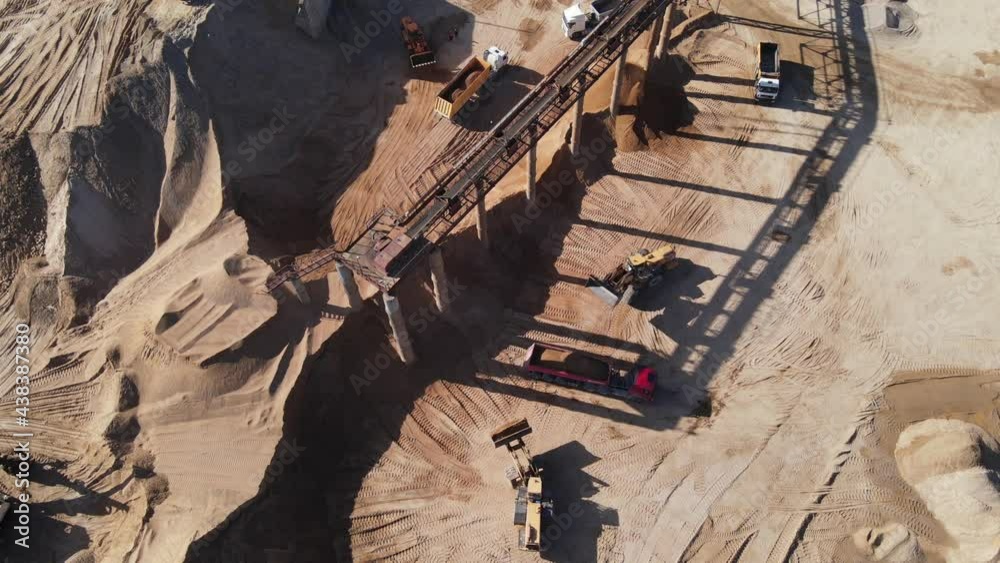 Wheel loader loading sand into dump truck in opencast quarry. Truck ...