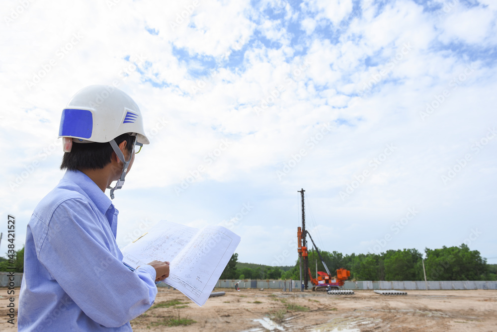 Young engineer checking progress pile driving of diesel hammer pile ...