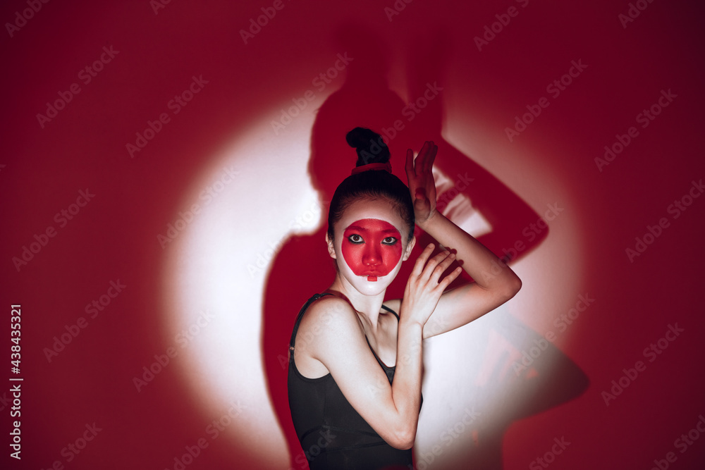 Ballet dancer dancing over red studio background. Modern design ...