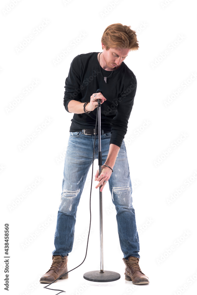 Young good-looking rock singer adjusting microphone stand height. Full ...
