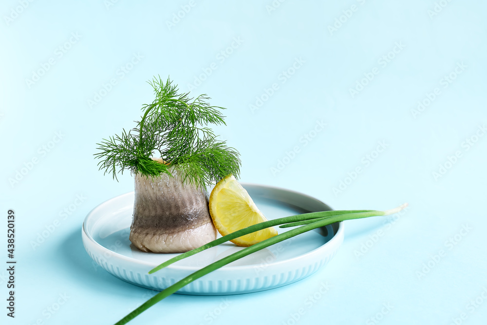 Herring fillet rolled up with lemon slice and dill on the plate on ...