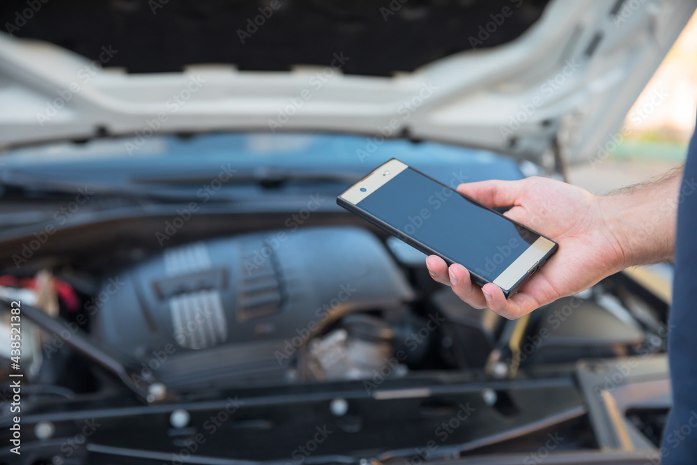 Hand of car mechanic holding phone Stock Photo | Adobe Stock