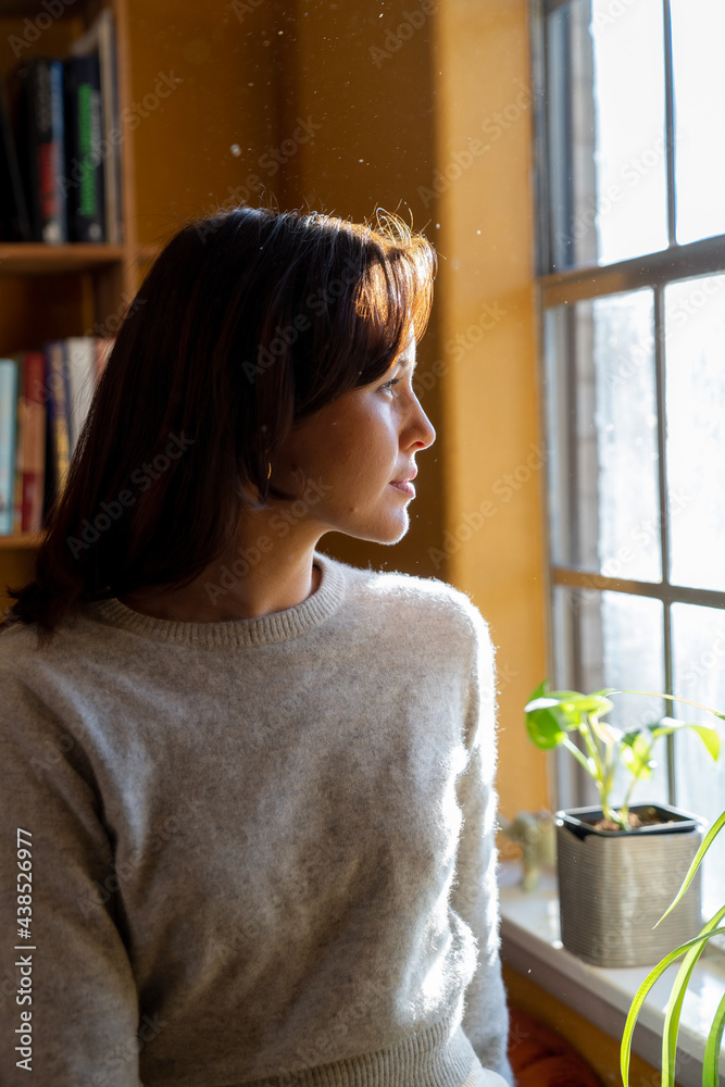 Profile of woman looking out window Stock Photo | Adobe Stock