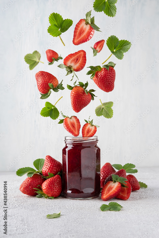 Strawberry jam in glass jar and falling pieces of strawberry ...