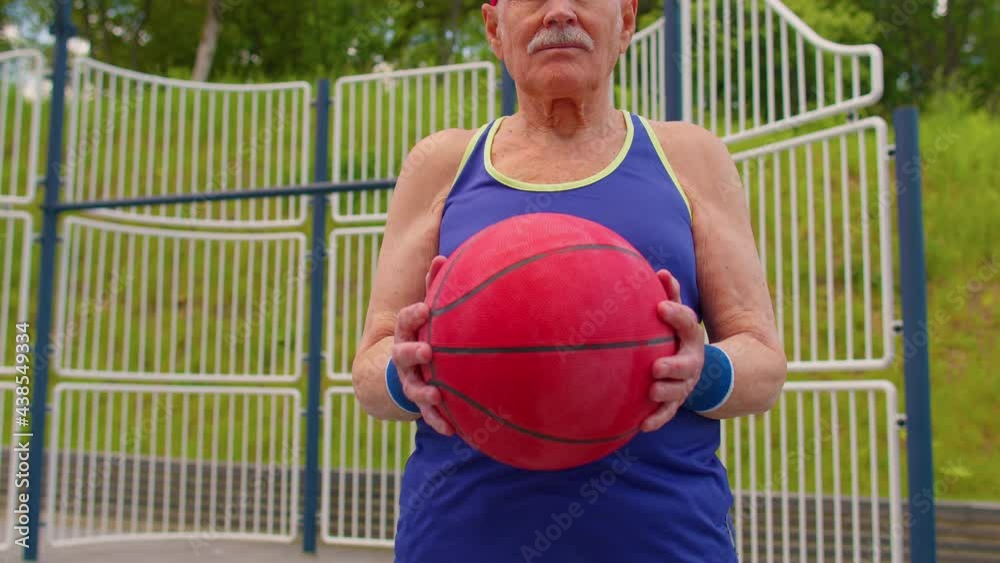 Senior sportsman grandfather athlete posing playing with ball outdoors ...
