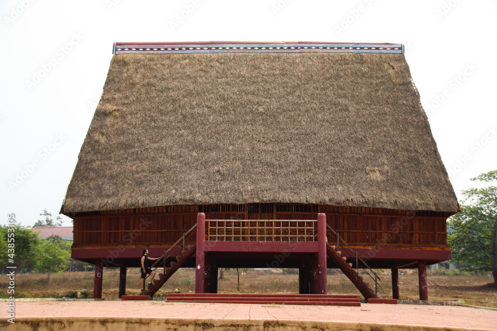 A tourist exploring a traditional architecture of a Bahnar ethnic stilt ...