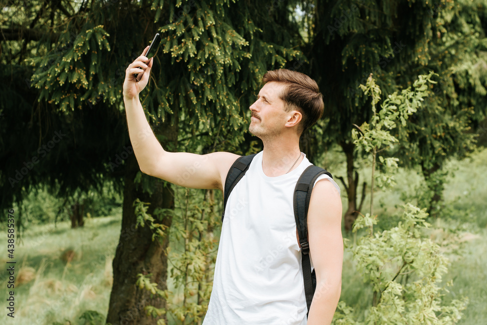 Man trying to catch signal on mobile phone outdoors in the forest. Sad ...