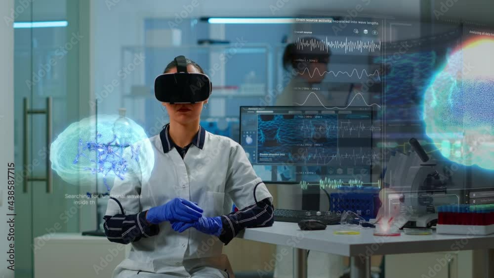 Scientist in lab wearing VR goggles working on augmented reality ...