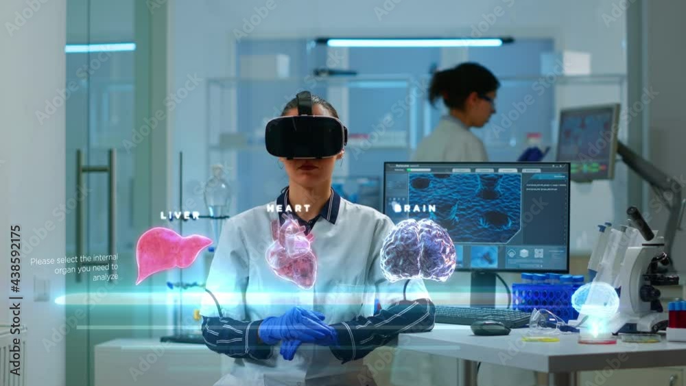 Female scientist in lab wearing VR goggles working on augmented reality virtual holograms. Lab ...