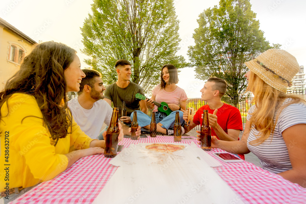 millennial people having fun with singing, eating pizza, drinking beers ...
