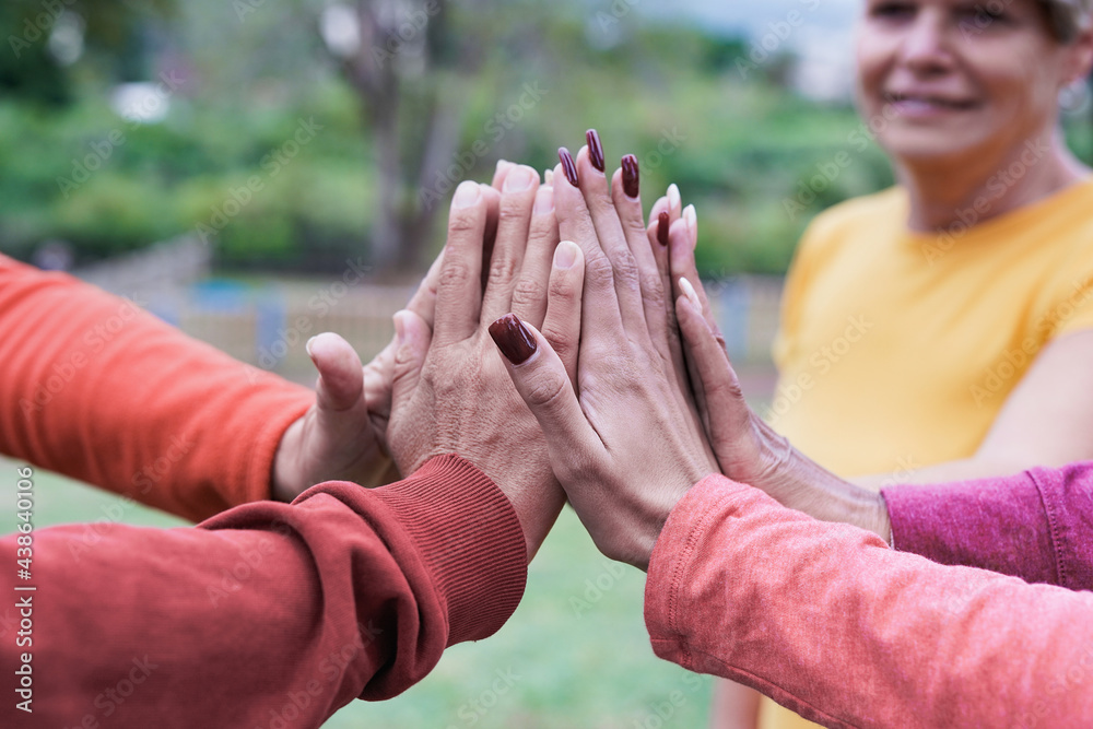 Stacking hands of multiracial women - Multi generational people with ...