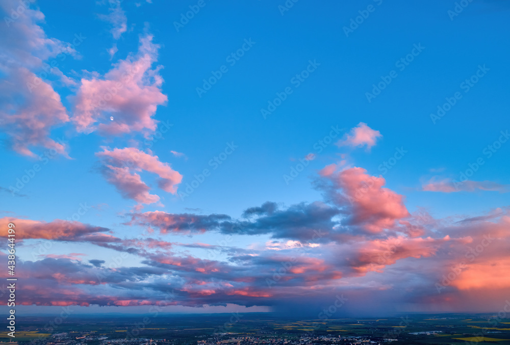 Colorful blue sky background, pink-orange dramatic clouds, aerial ...